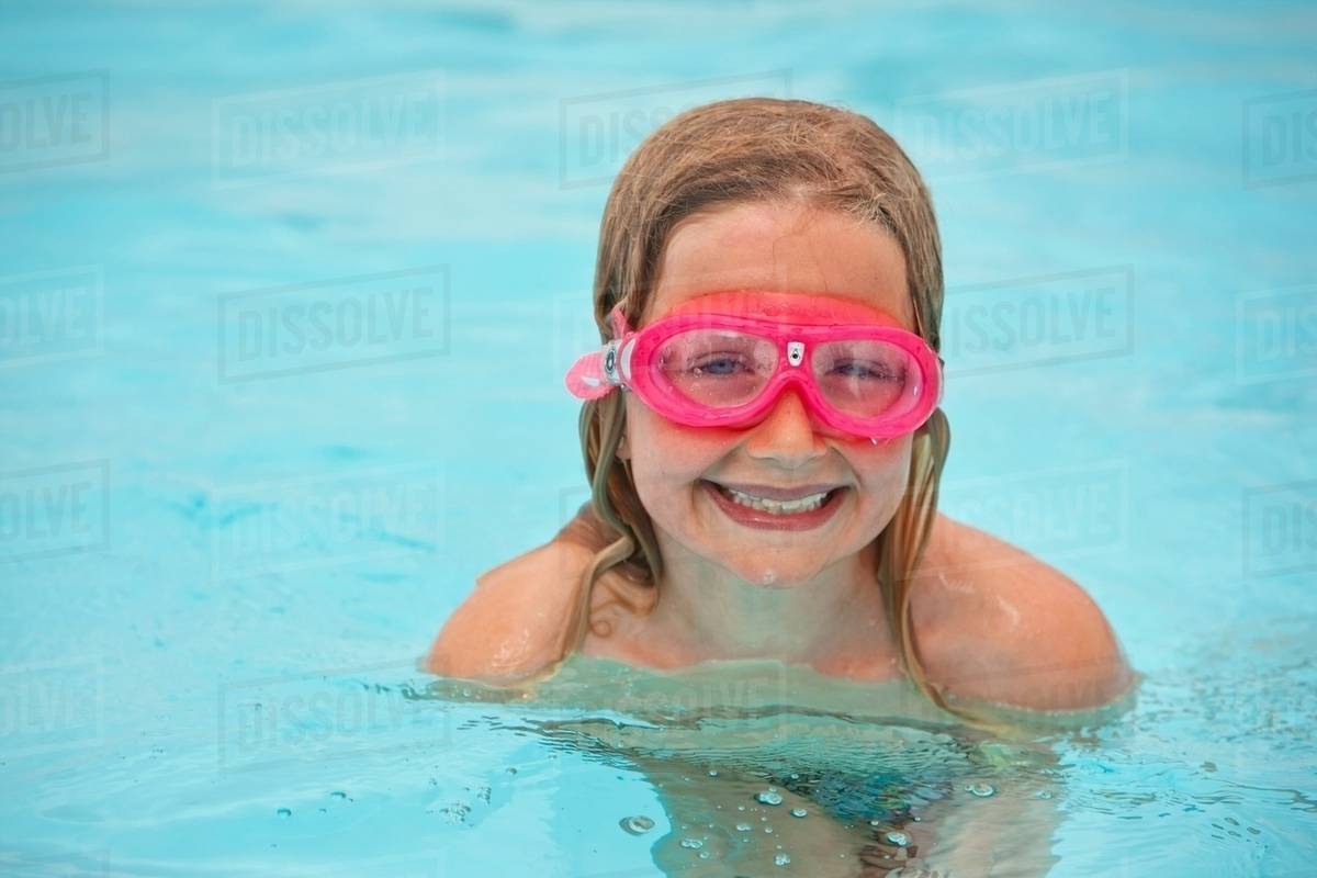 Girl wearing goggles in swimming pool - Royalty-free Stock Photo | Dissolve