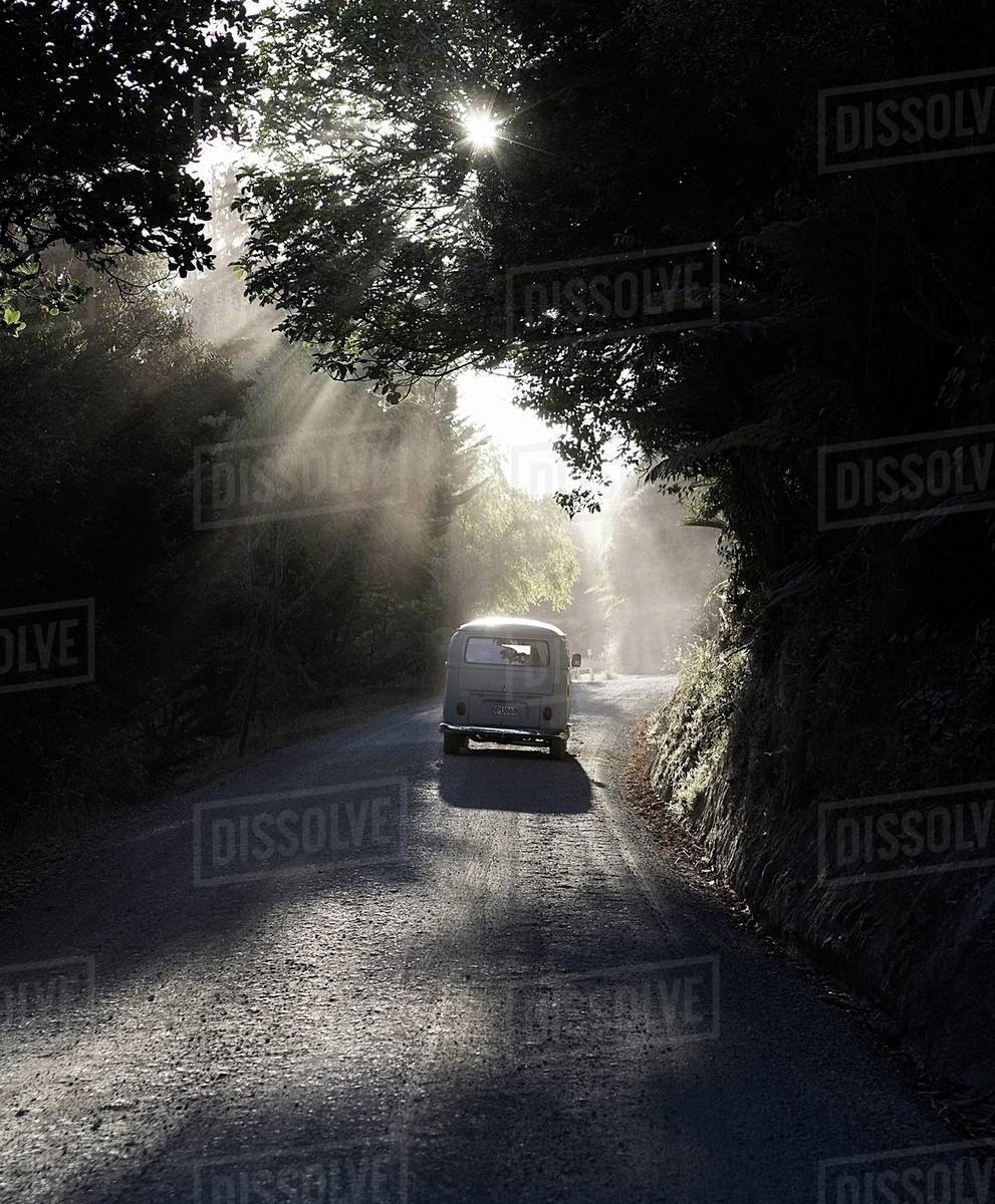 Car driving down rural road - Royalty-free Stock Photo | Dissolve