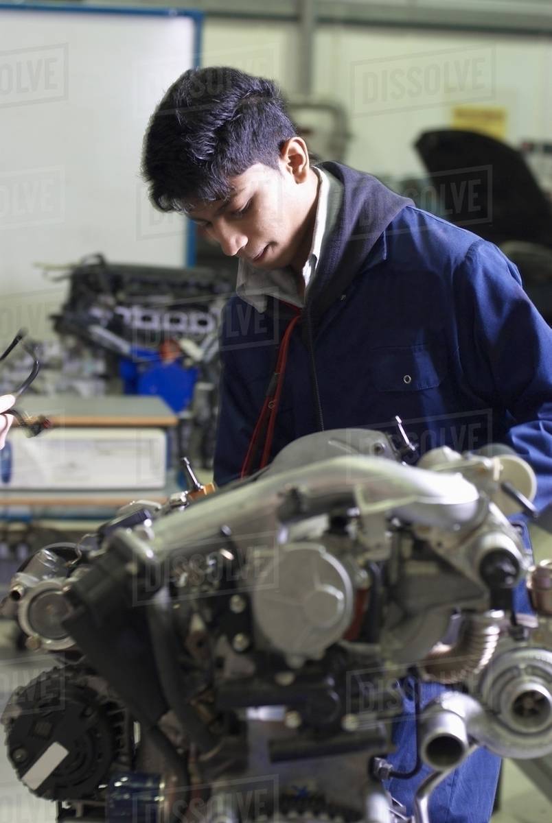 Student working on car engine - Royalty-free Stock Photo | Dissolve
