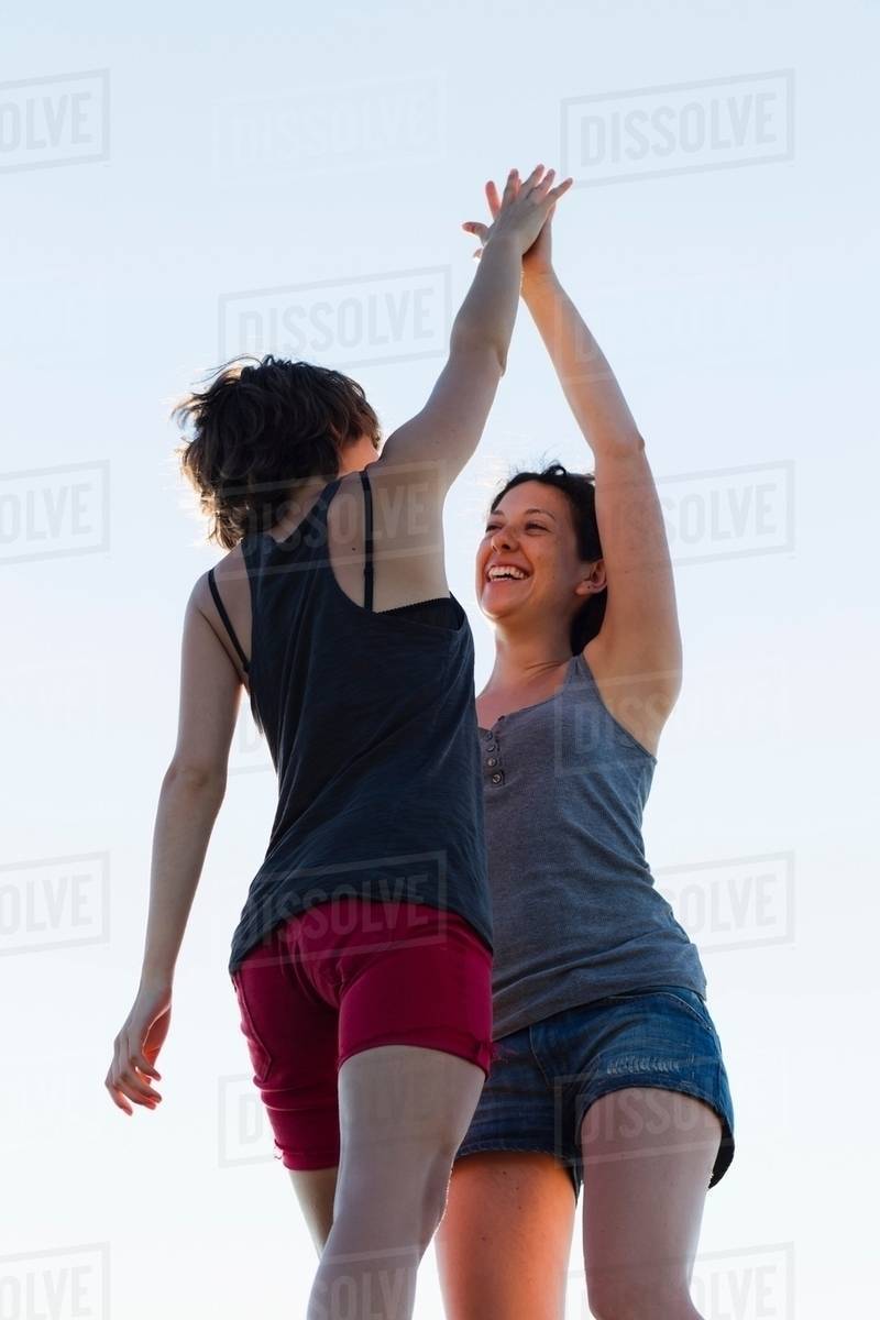Women high-fiving outdoors - Royalty-free Stock Photo | Dissolve