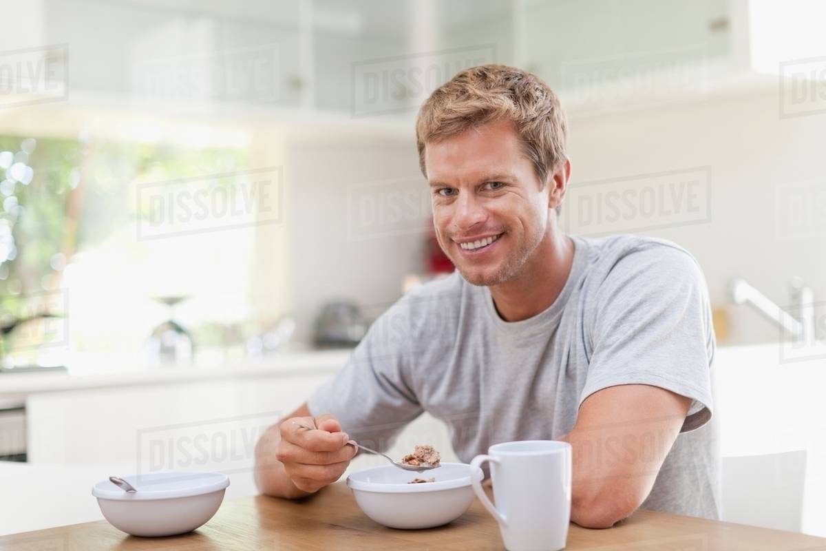 Man eating breakfast in kitchen - Stock Photo - Dissolve