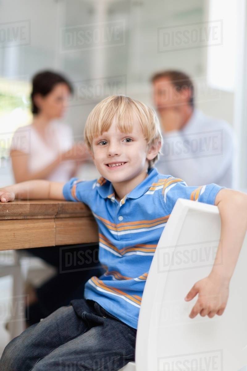 Smiling boy sitting at table - Royalty-free Stock Photo | Dissolve