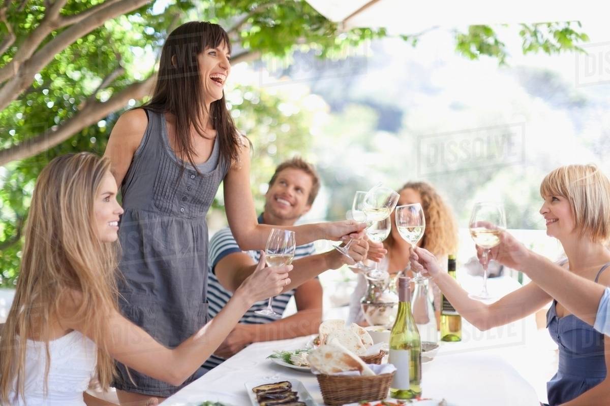 Friends toasting each other outdoors - Stock Photo - Dissolve