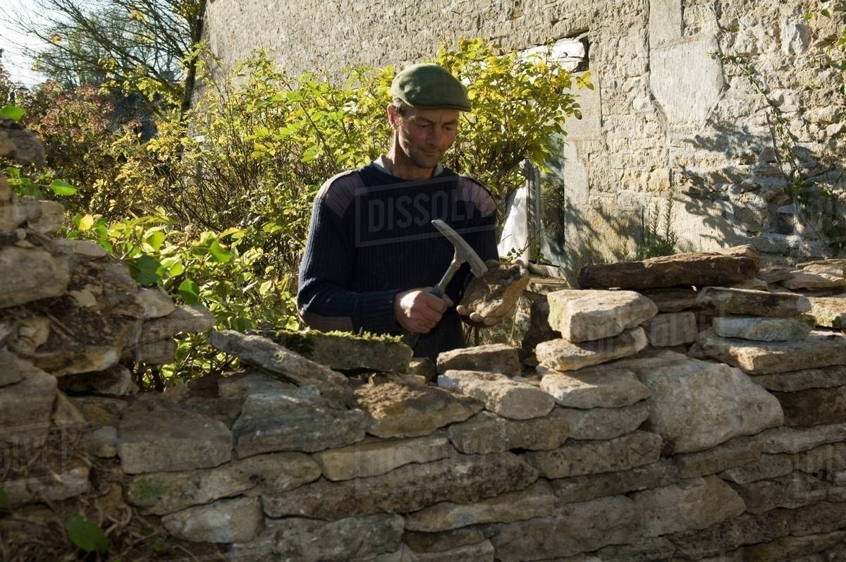 Man building stone wall - Royalty-free Stock Photo | Dissolve