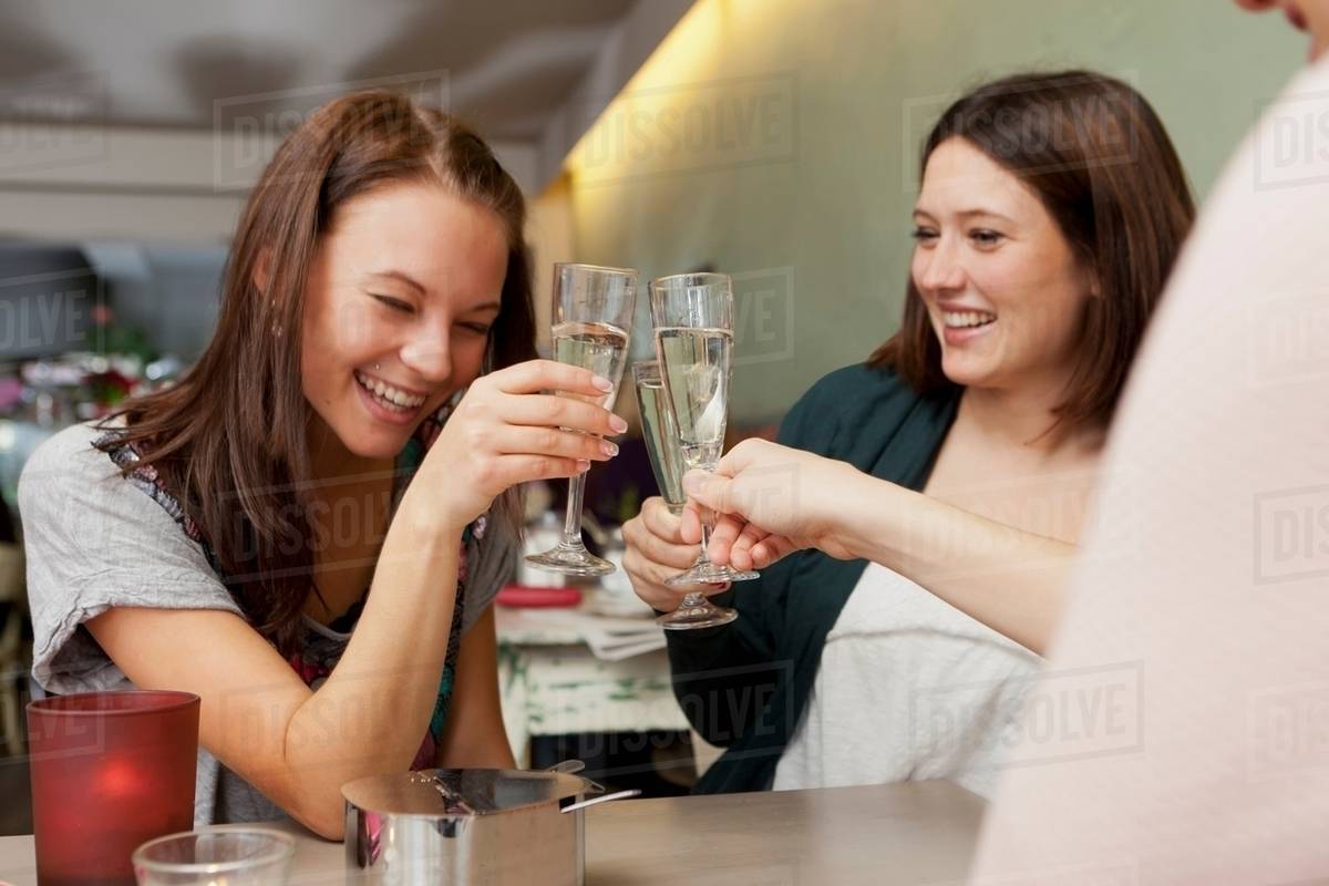 Women toasting with champagne in cafe - Royalty-free Stock Photo | Dissolve