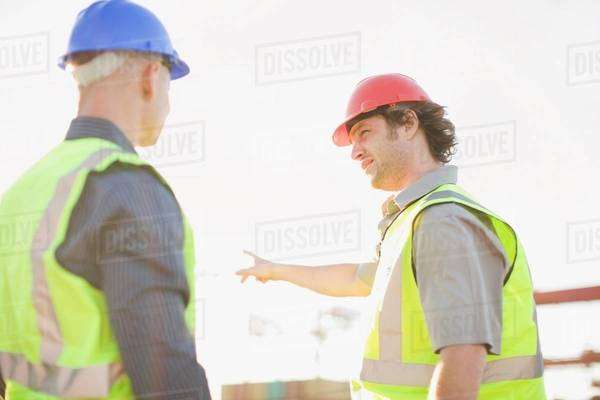Construction workers talking on site - Royalty-free Stock Photo | Dissolve