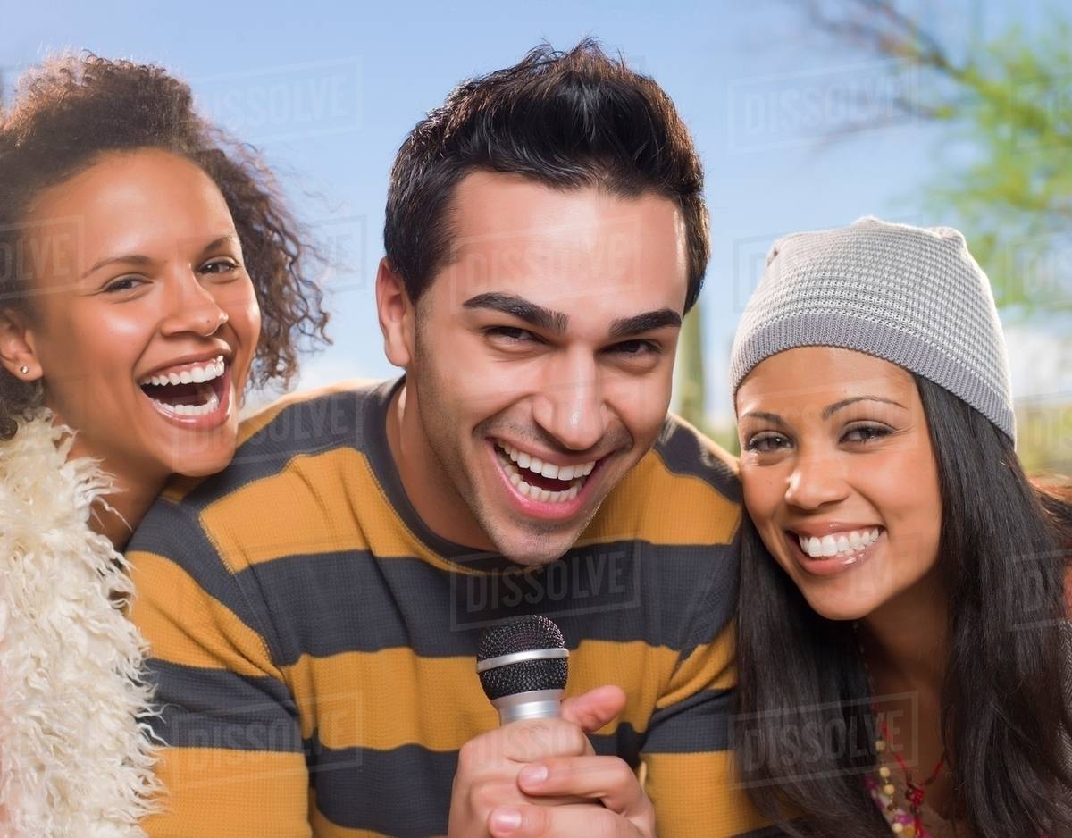 Friends singing together outdoors - Royalty-free Stock Photo | Dissolve