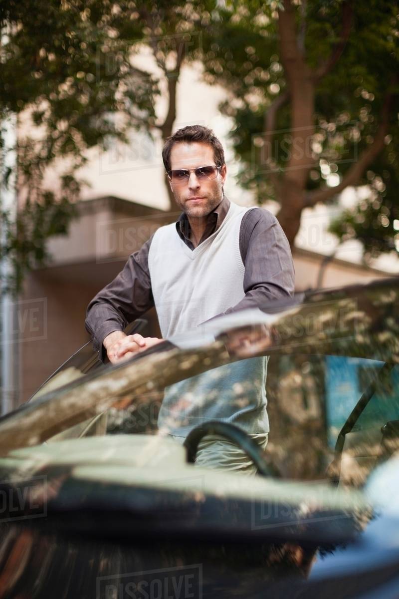 Man leaning on sports car - Royalty-free Stock Photo | Dissolve