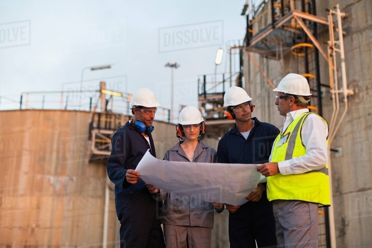 Workers reading blueprints at plant - Stock Photo - Dissolve