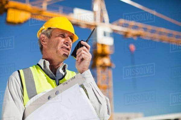 Worker using walkie talkie on site - Royalty-free Stock Photo | Dissolve