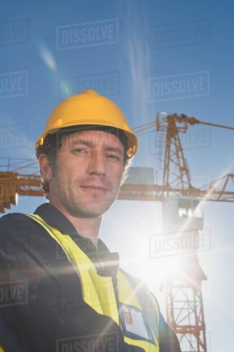 Worker standing at construction site - Stock Photo - Dissolve