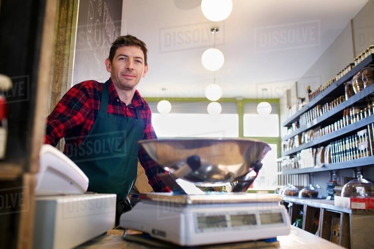 Grocer working behind counter at store - Royalty-free Stock Photo ...