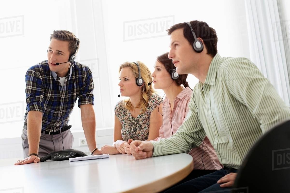 Business people in headsets in meeting - Stock Photo - Dissolve