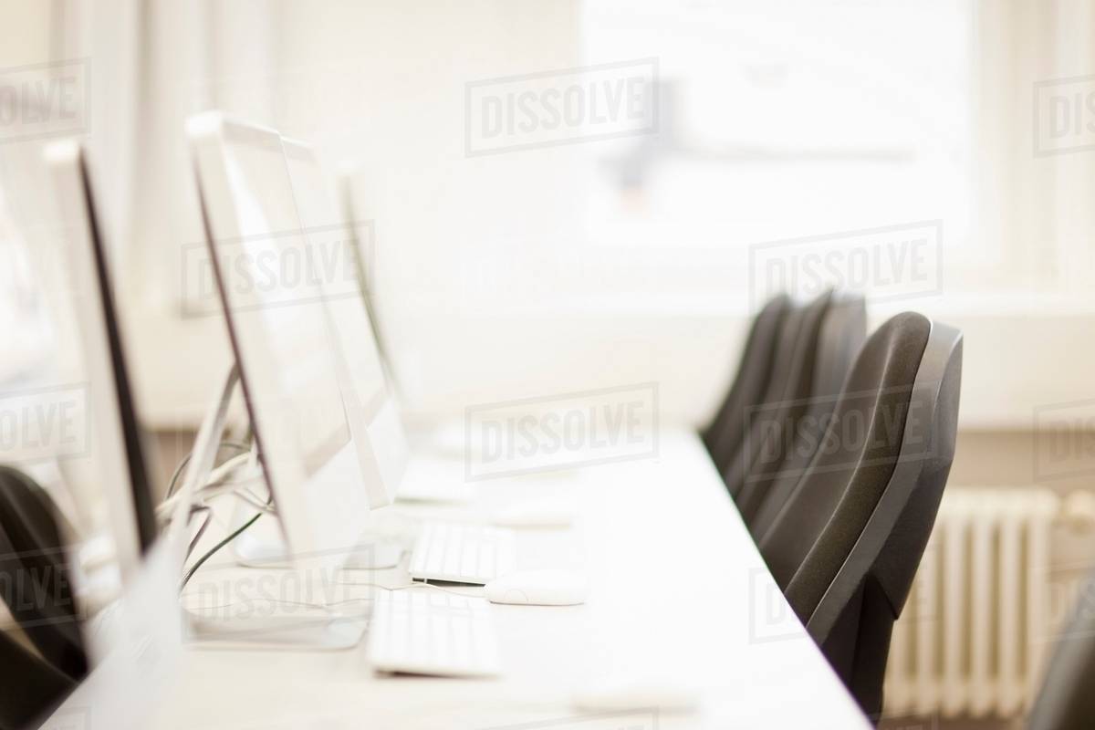 Empty computer desks in office - Stock Photo - Dissolve