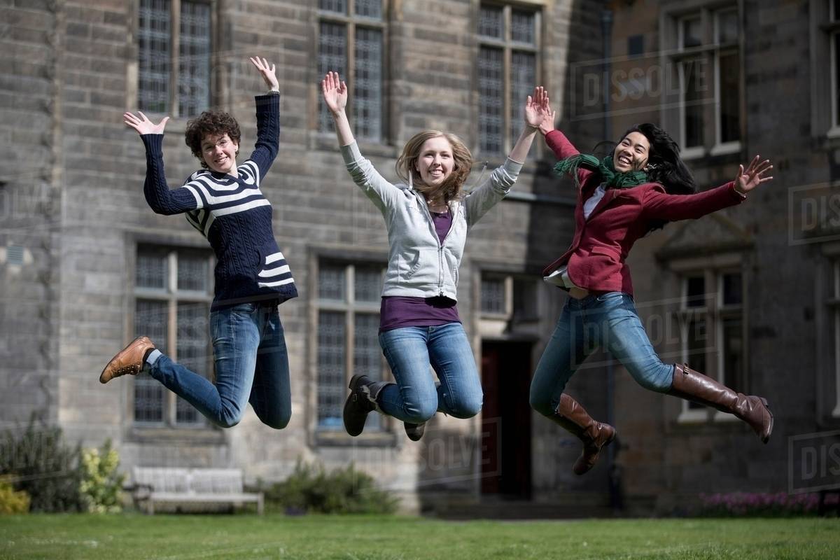 Students jumping for joy outdoors - Stock Photo - Dissolve