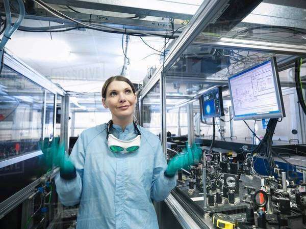 Scientist making juggling motions by monitors with laser beam profiles ...
