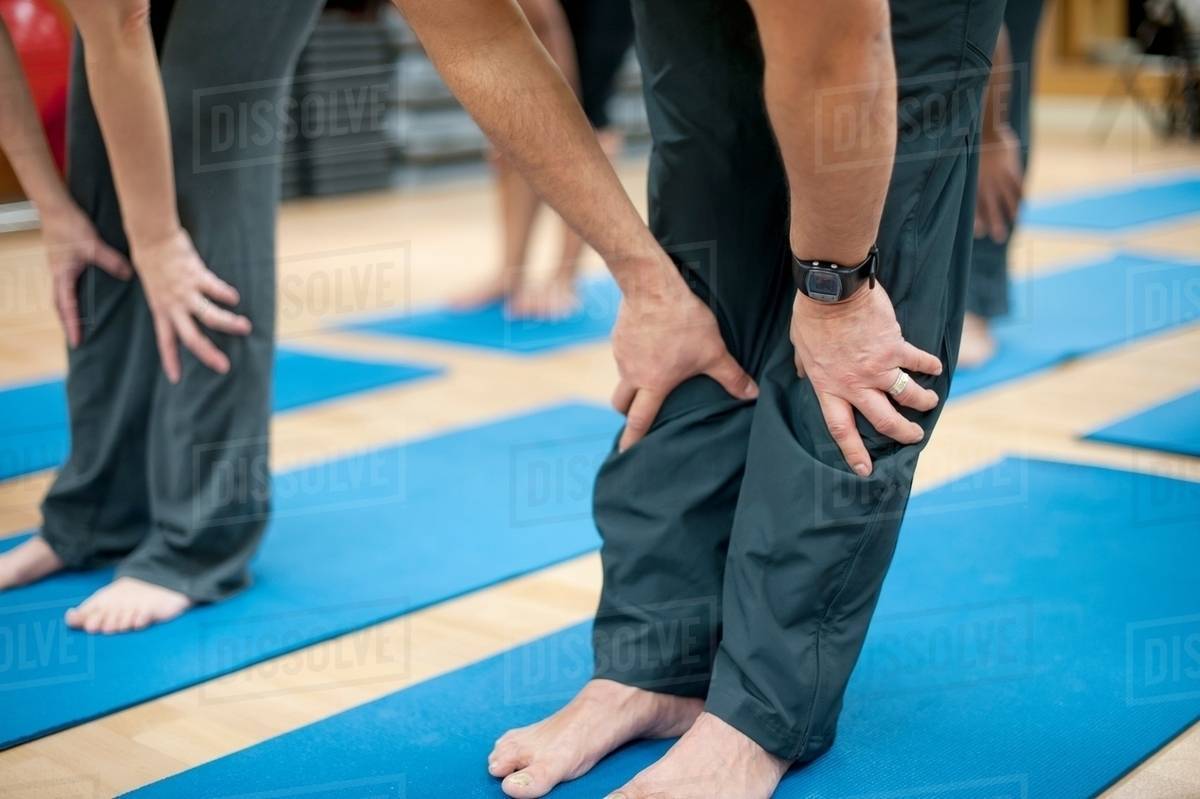 People practicing yoga in studio - Stock Photo - Dissolve
