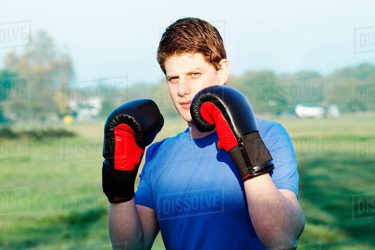 Boxer holding up gloves outdoors - Royalty-free Stock Photo | Dissolve