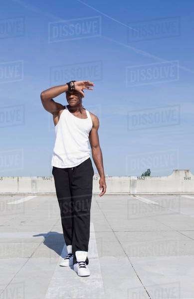 Man shielding his eyes on urban rooftop - Royalty-free Stock Photo ...