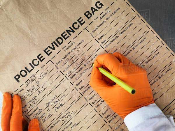 Scientist filling out evidence bag - Royalty-free Stock Photo | Dissolve