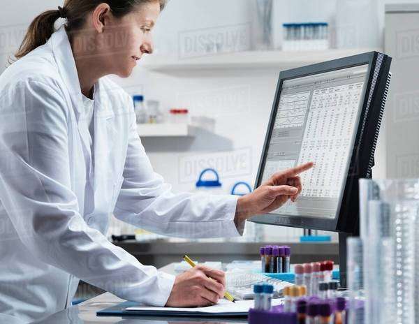 Scientist using computer in lab - Royalty-free Stock Photo | Dissolve
