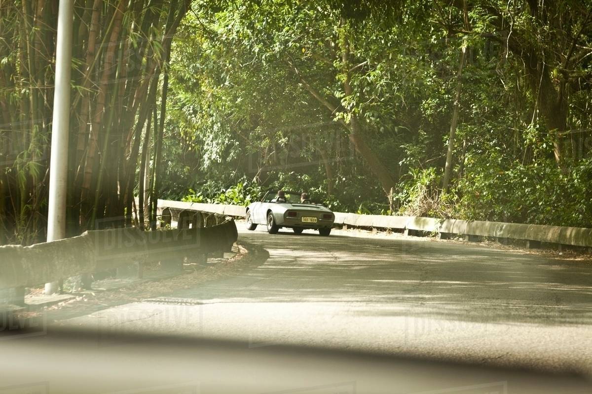 Two men in convertible car on road, rear view - Royalty-free Stock ...