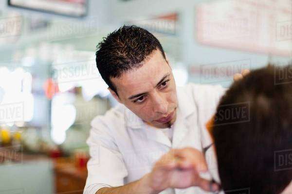 Barber working on client in shop - Royalty-free Stock Photo | Dissolve