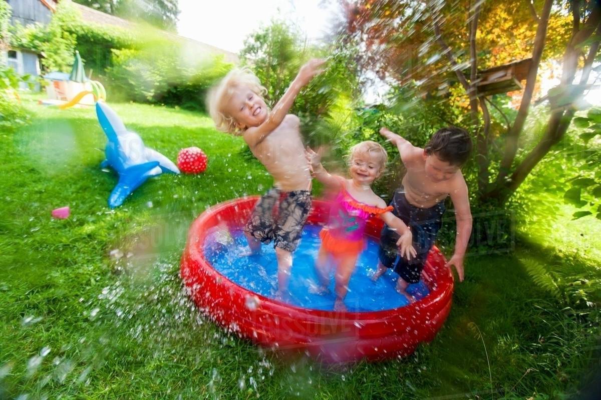 Children splashing in paddling pool - Stock Photo - Dissolve