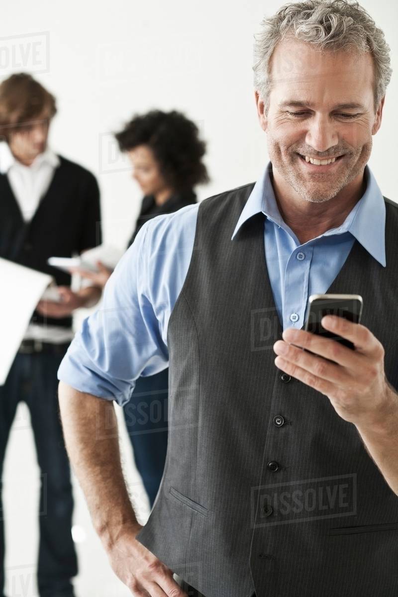 Businessman using cell phone in office - Royalty-free Stock Photo ...