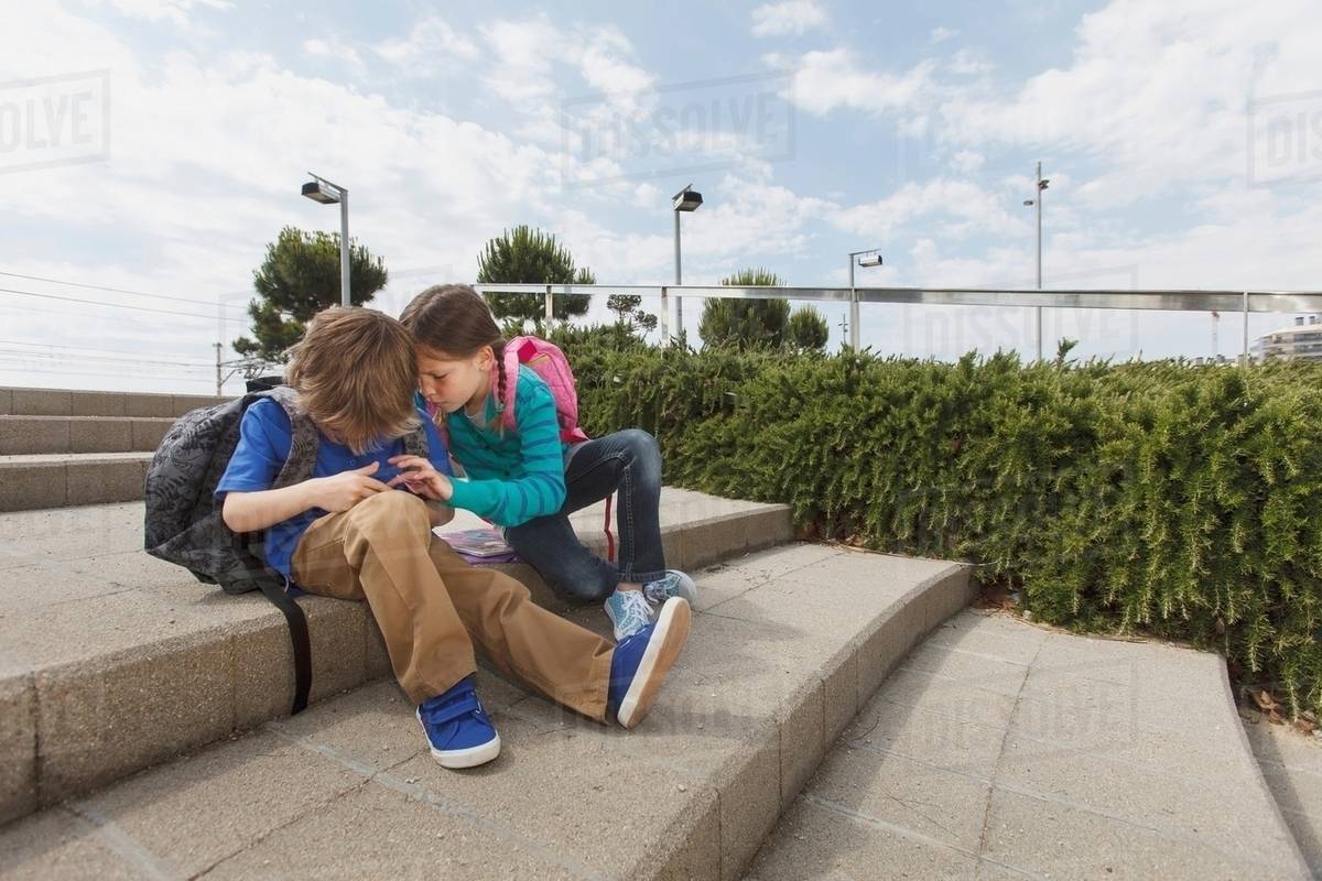 Children talking on steps outdoors - Royalty-free Stock Photo | Dissolve