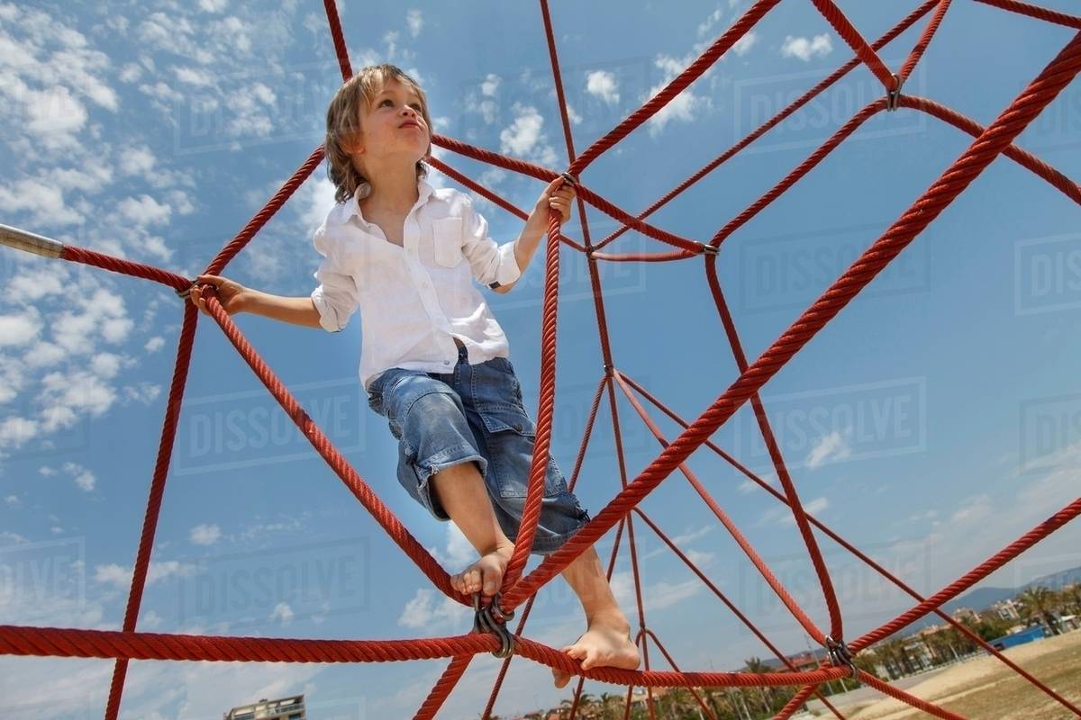 Boy playing on ropes on beach - Royalty-free Stock Photo | Dissolve
