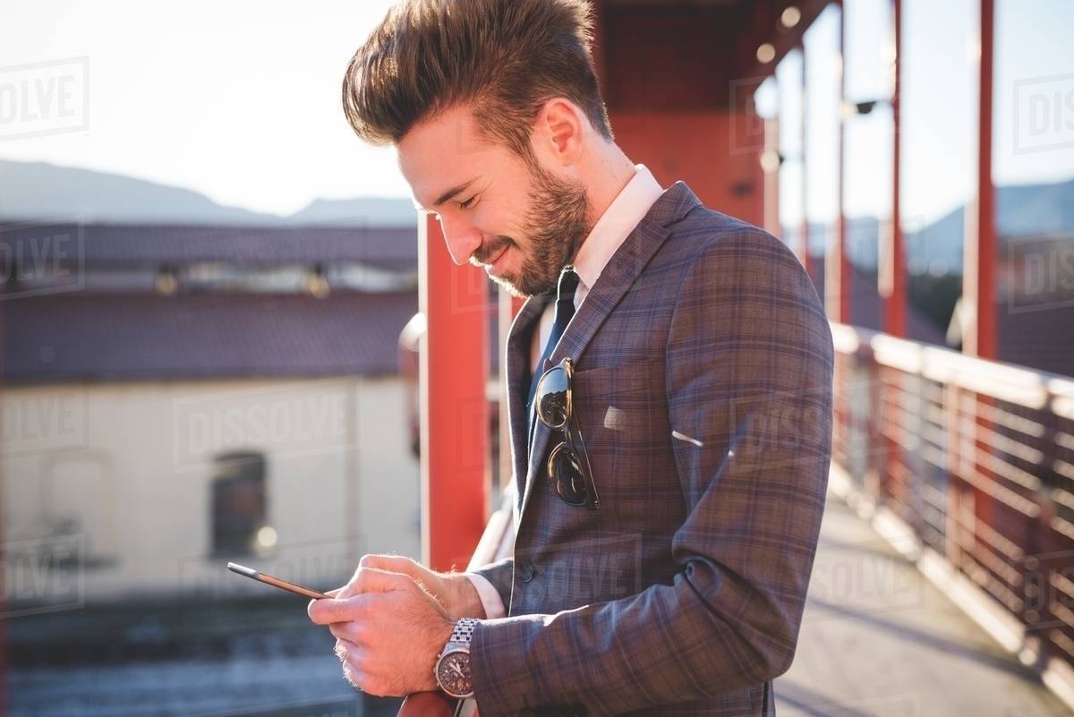 Young man reading smartphone texts on footbridge - Royalty-free Stock ...