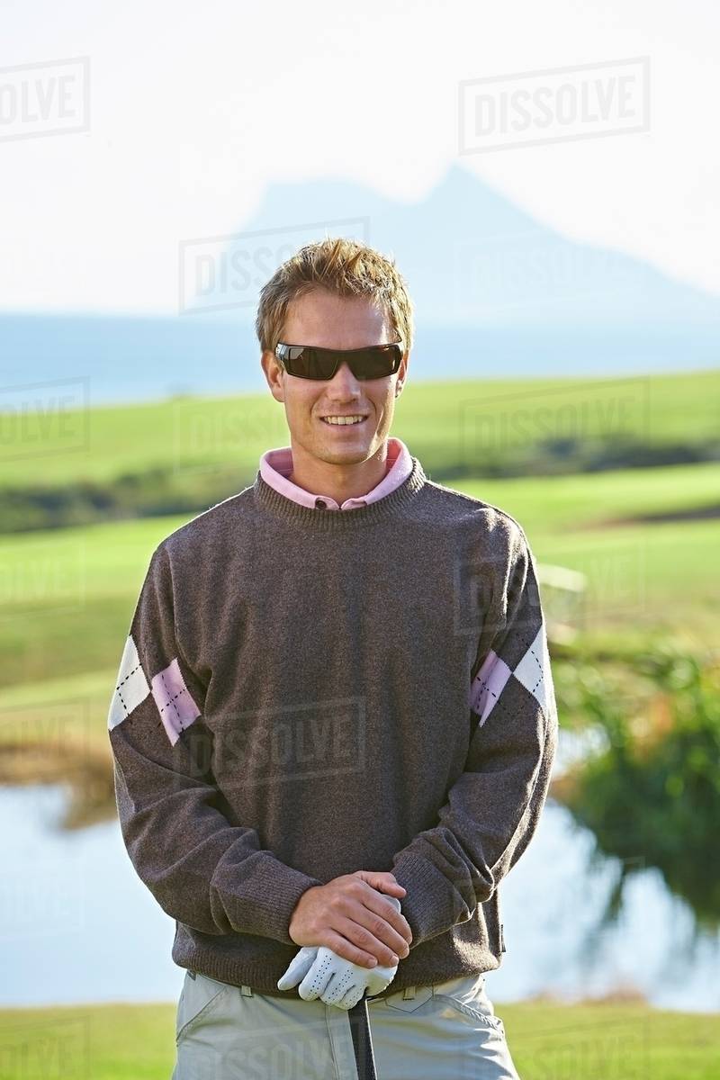 Golfer wearing sunglasses looking at camera smiling - Royalty-free ...