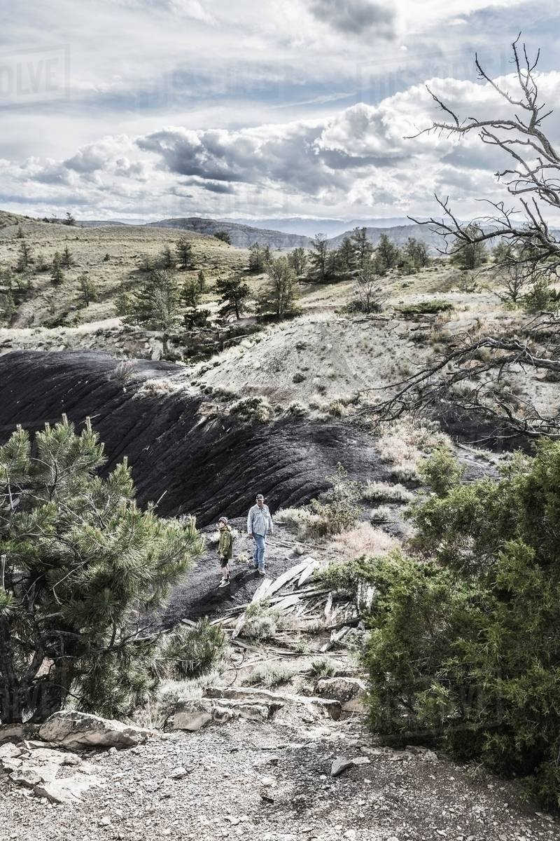 Father and son hiking among rock formations, Bridger, Montana, USA ...