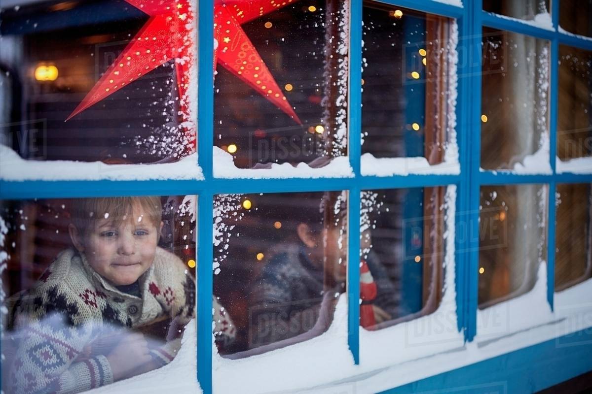 Two brothers looking out of cabin window at Christmas - Stock Photo ...