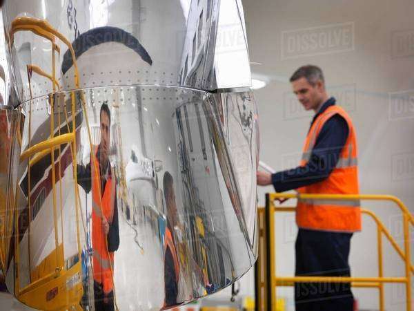 Engineer works on jet aircraft - Stock Photo - Dissolve