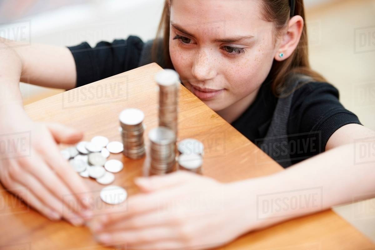 Girl looking at piles of money - Royalty-free Stock Photo | Dissolve