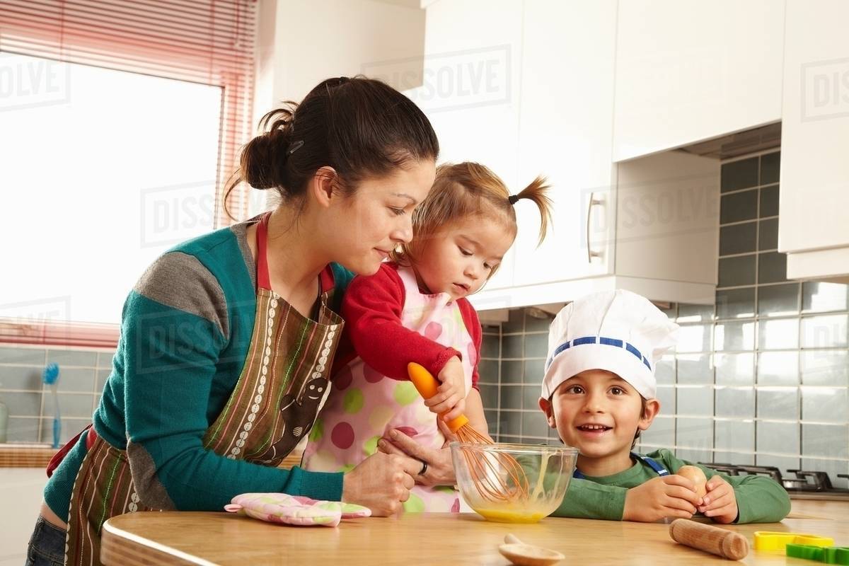 Mother cooking with children in kitchen - Royalty-free Stock Photo ...