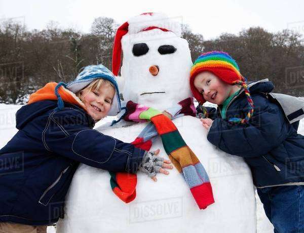 Two boys hugging a snowman - Royalty-free Stock Photo | Dissolve