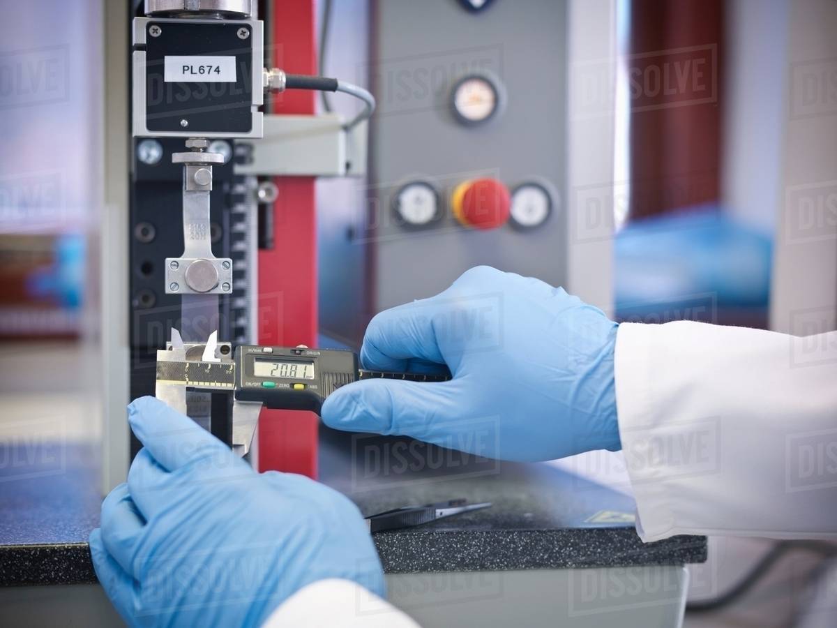 Scientist's hands conducting stretch test in laboratory, holding ...