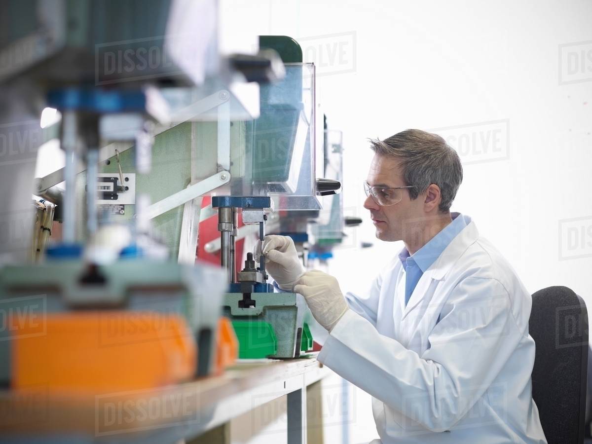 Male worker sat at workbench using equipment in laboratory - Stock ...