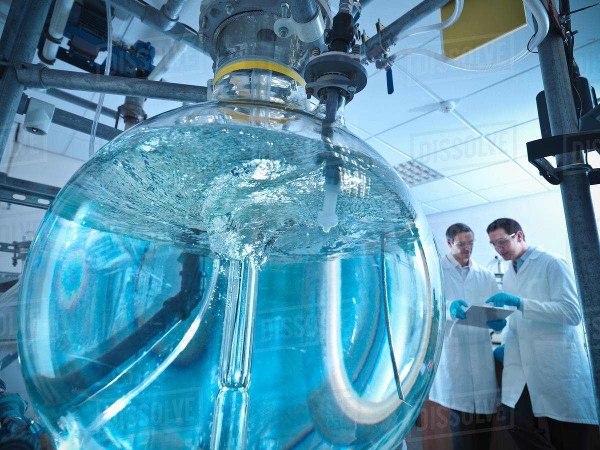 Scientists with laboratory mixing vessel - Stock Photo - Dissolve