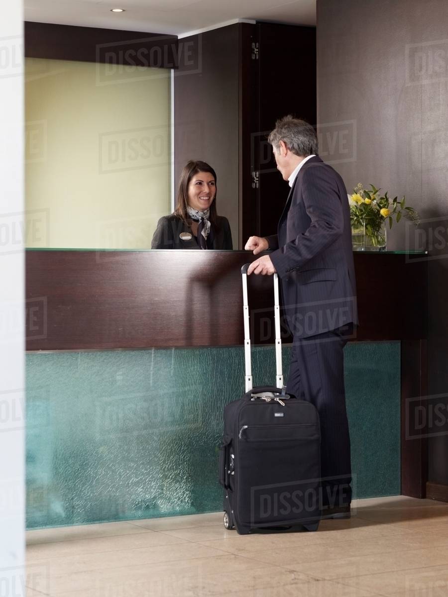 Senior man checking in at front desk of a hotel - Royalty-free Stock ...
