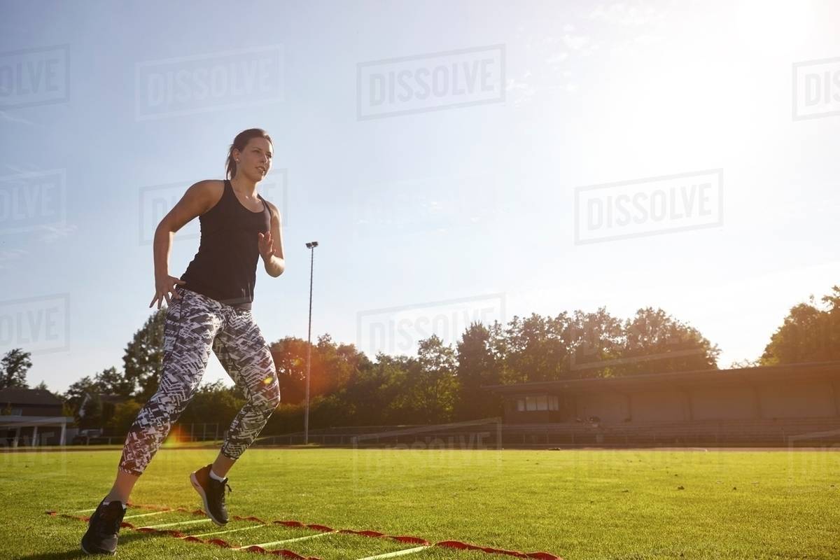 Young woman training on agility ladder on grass - Royalty-free Stock ...