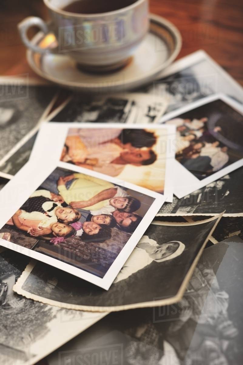 Pile of family photographs on table, next to tea cup - Royalty-free ...