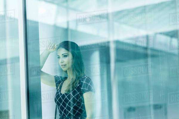 Woman behind glass window - Stock Photo - Dissolve