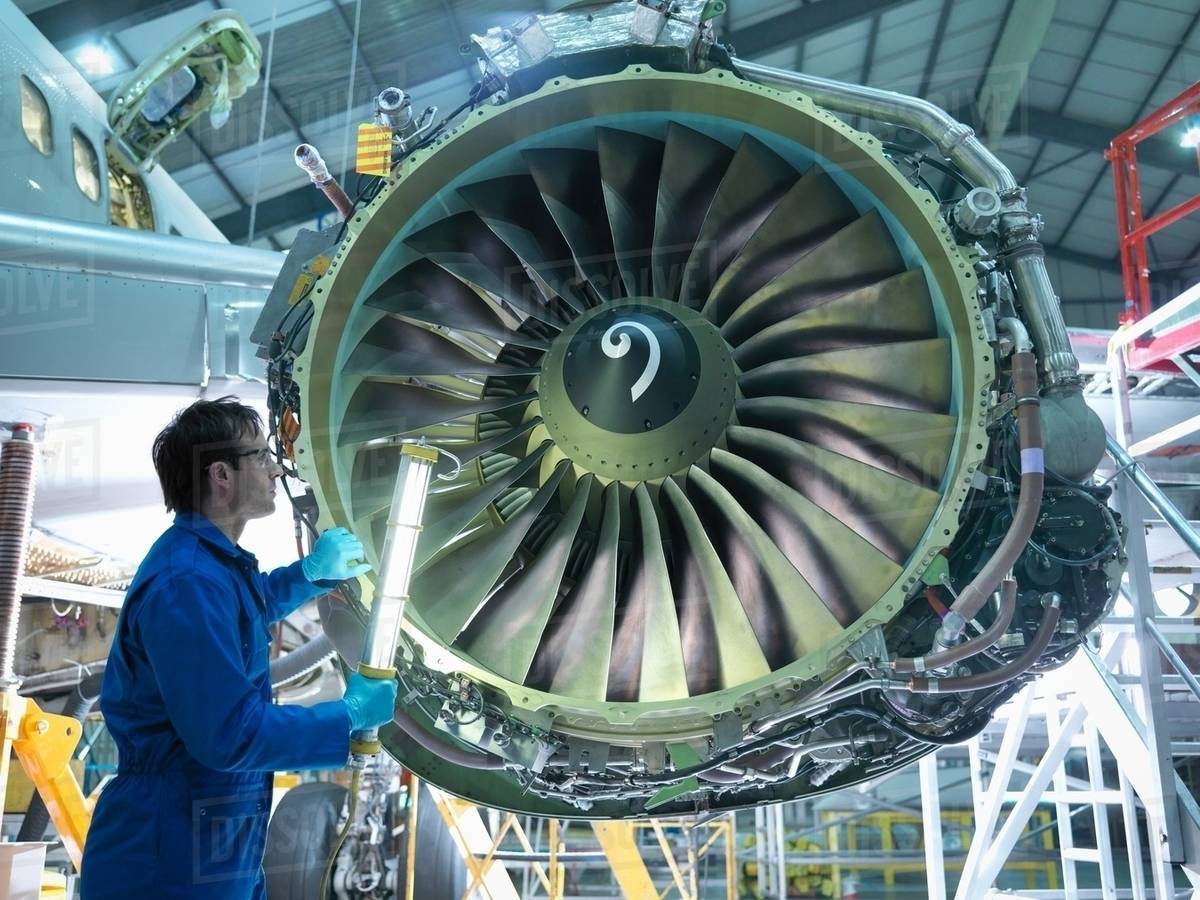 Engineer inspecting jet engine in aircraft maintenance factory - Stock ...