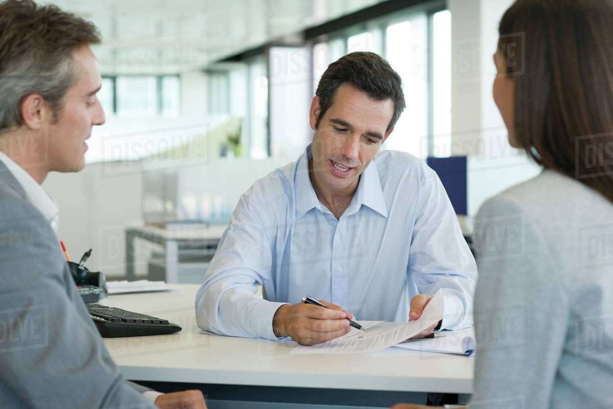 Businessman explaining document to clients - Stock Photo - Dissolve
