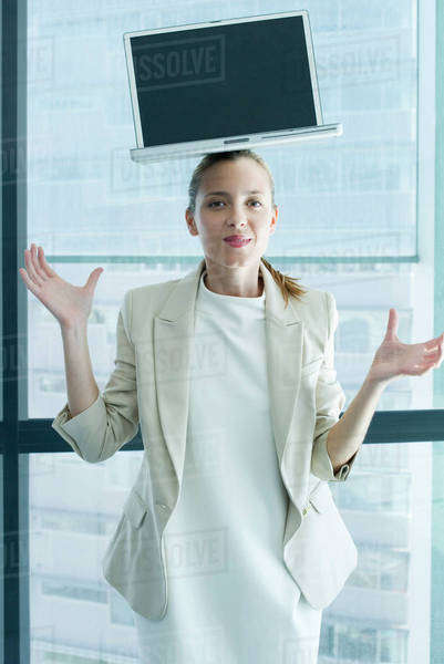 Businesswoman with laptop computer on head - Stock Photo - Dissolve