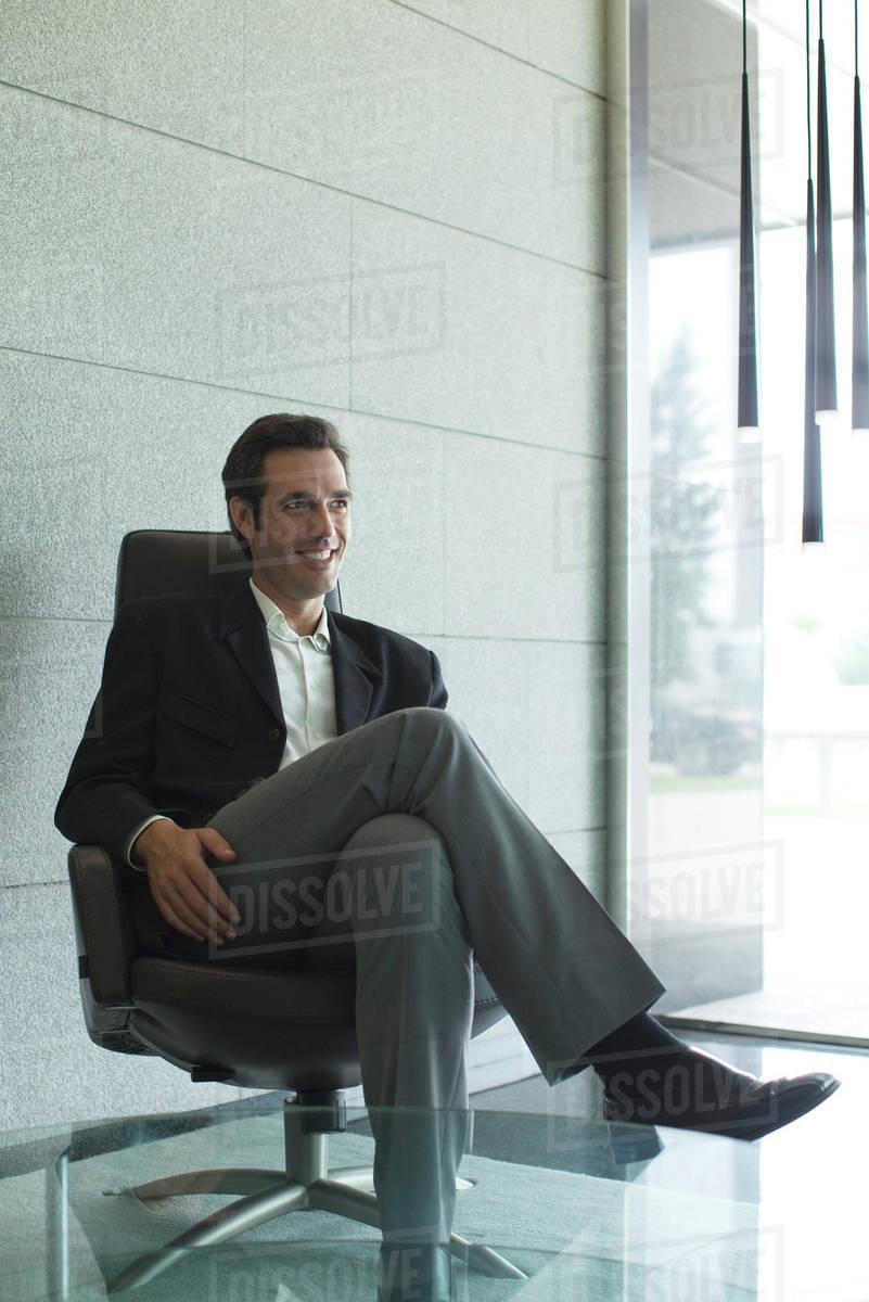 Executive sitting in lobby, backlit - Royalty-free Stock Photo | Dissolve